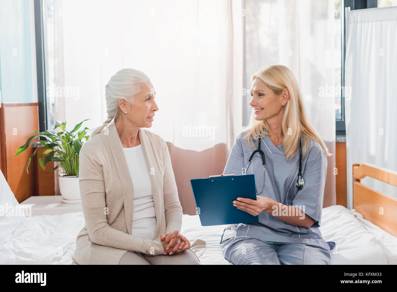 senior woman and nurse with clipboard Stock Photo - Alamy