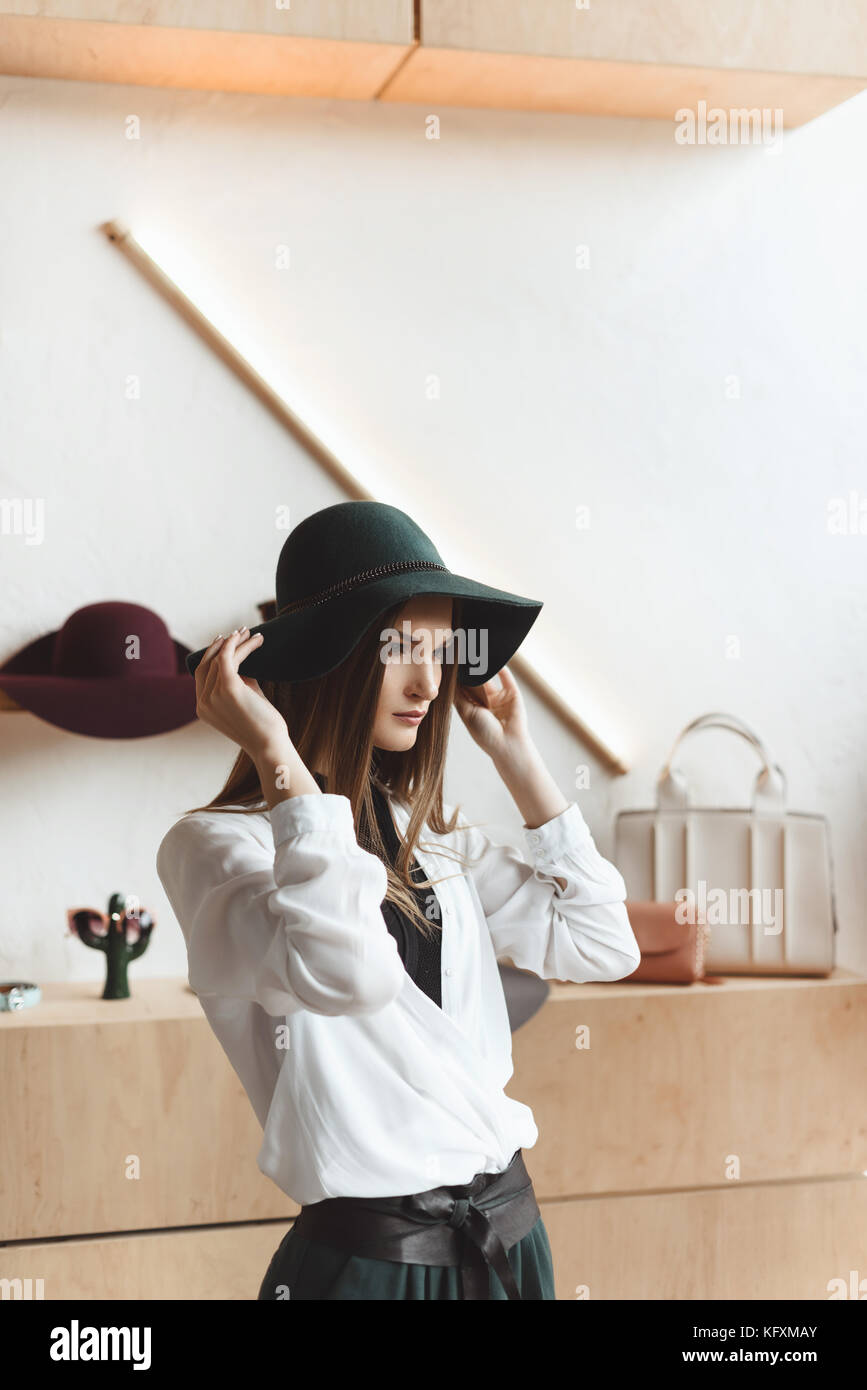 woman choosing hat in boutique Stock Photo - Alamy