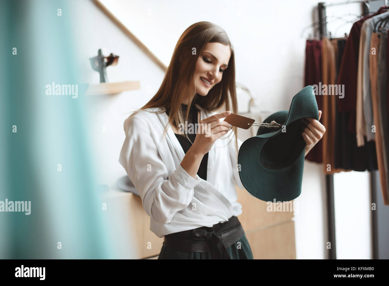 smiling woman choosing hat Stock Photo - Alamy