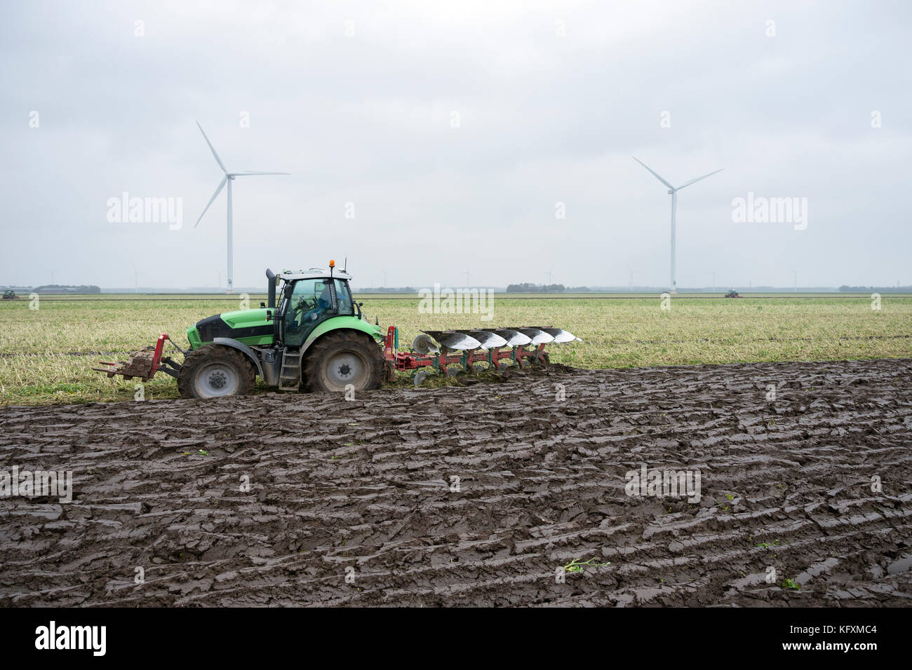 fresly plowed land and tractor with plough Stock Photo - Alamy