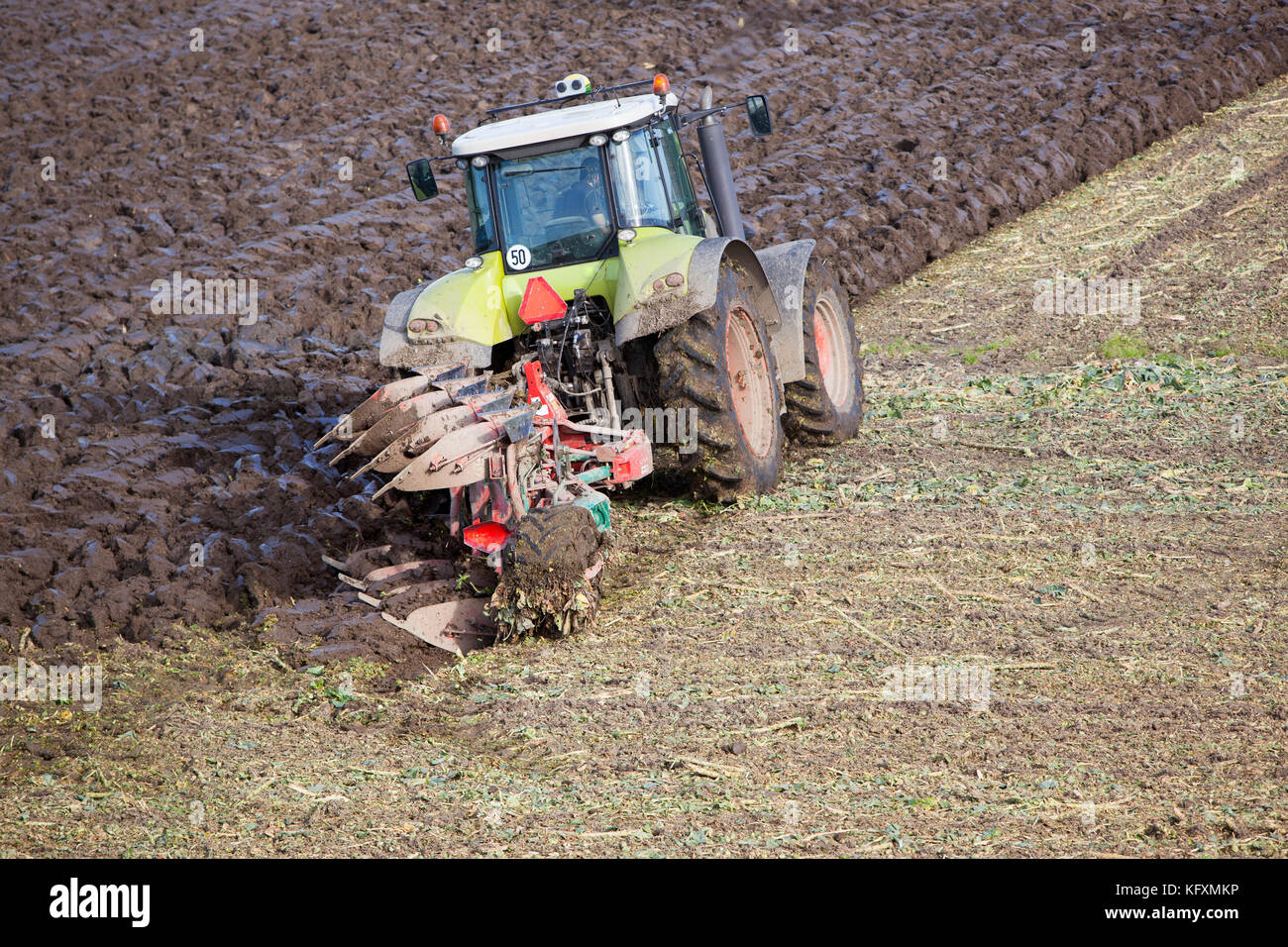 tractor and plow at work on field in the dutch province of flevoland ...