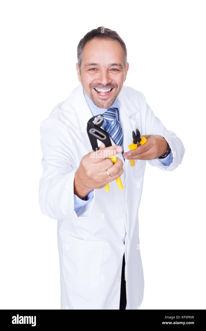 Smiling Male Doctor Holding Pliers On White Background Stock Photo - Alamy