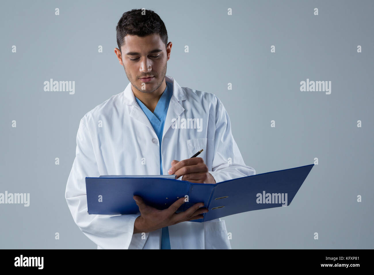 Doctor writing a reports in the file against white background Stock ...