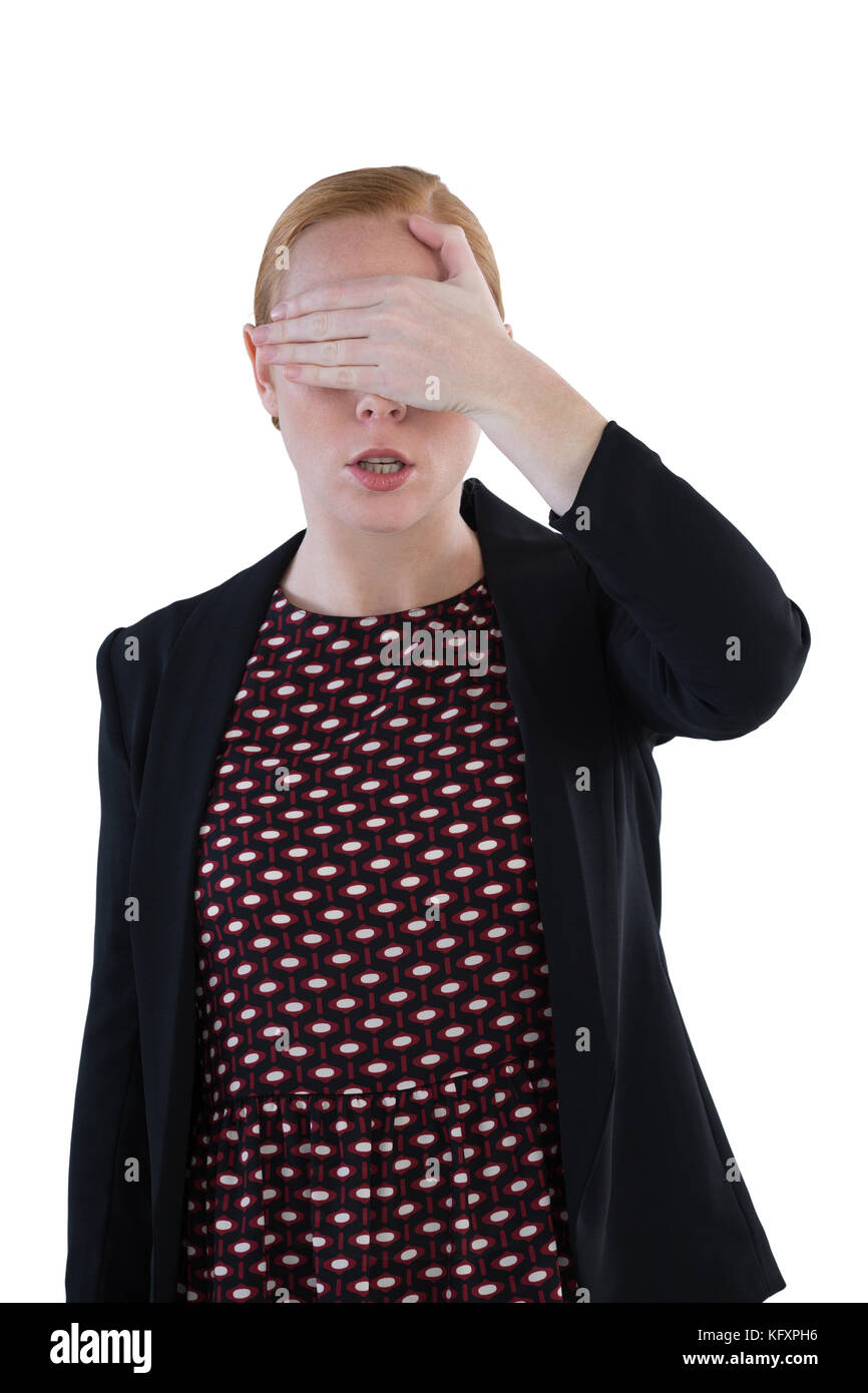 Woman covering both her eyes against white background Stock Photo - Alamy