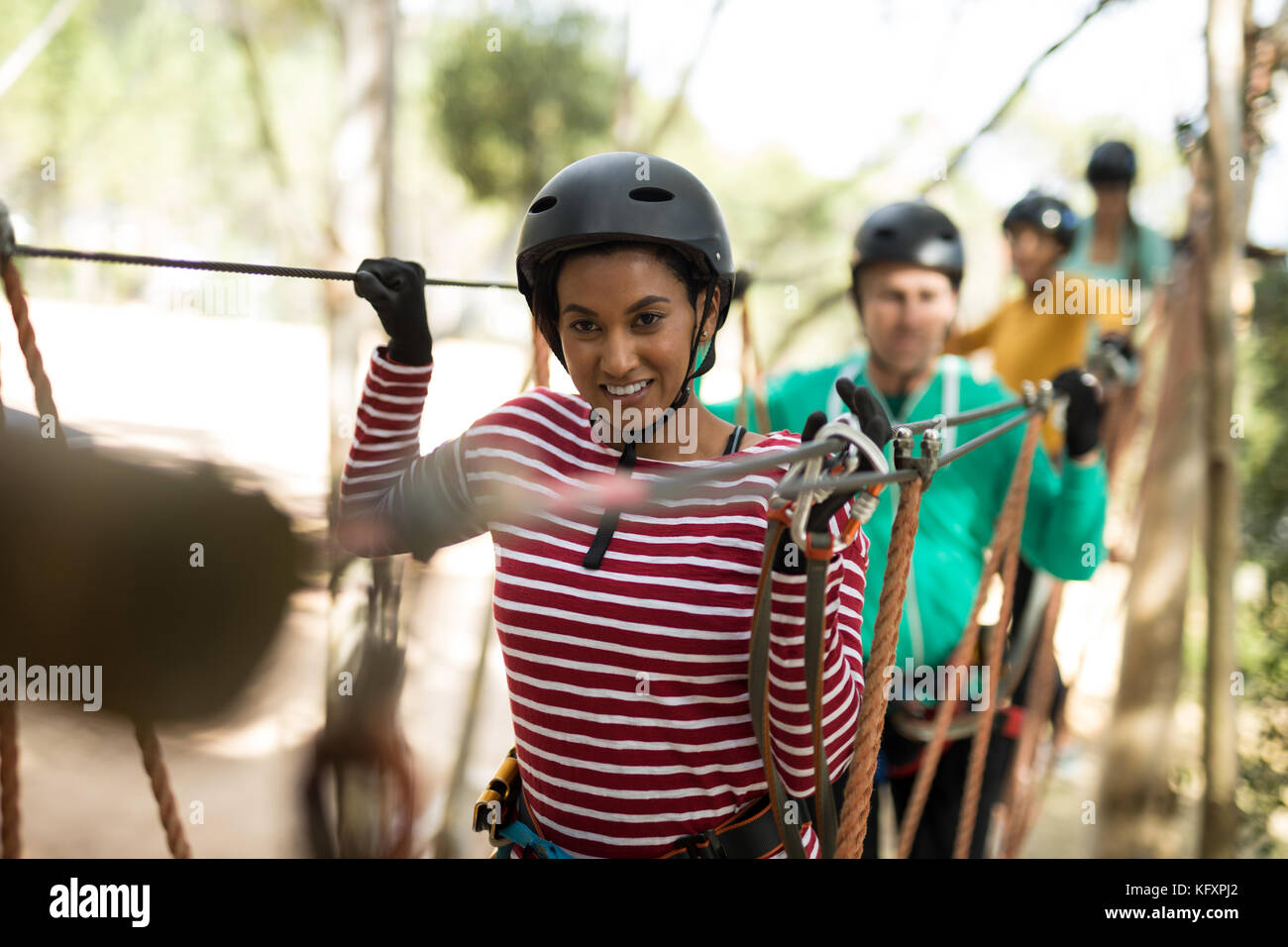 Friends enjoying zip line adventure in park on a sunny day Stock Photo ...