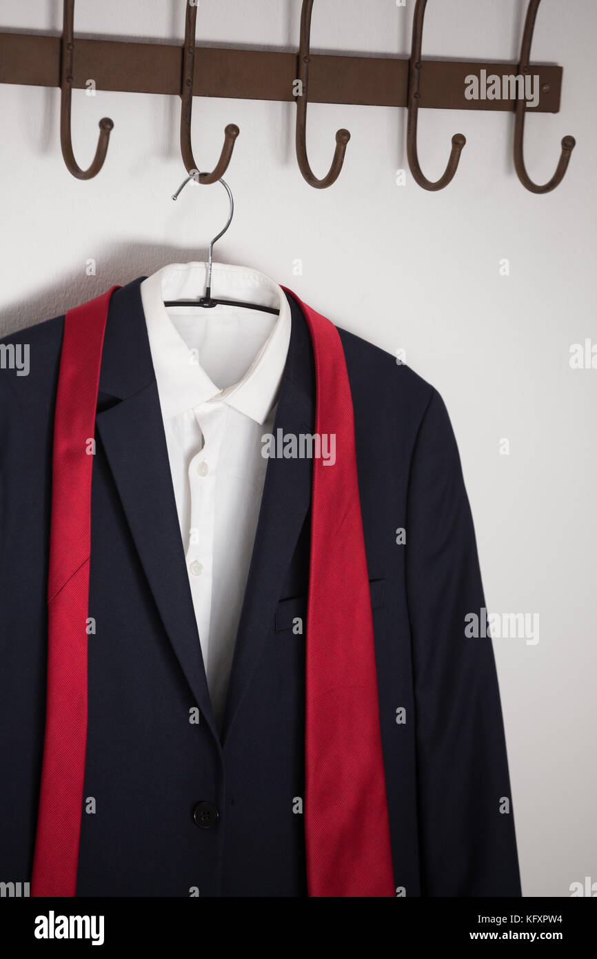 Close-up of blazer hanging on hook against white wall Stock Photo - Alamy