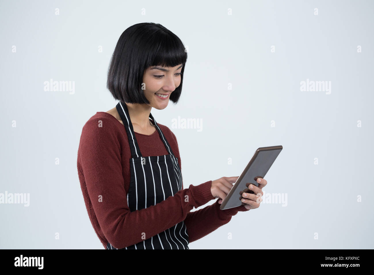Smiling waitress using digital tablet against white background Stock ...