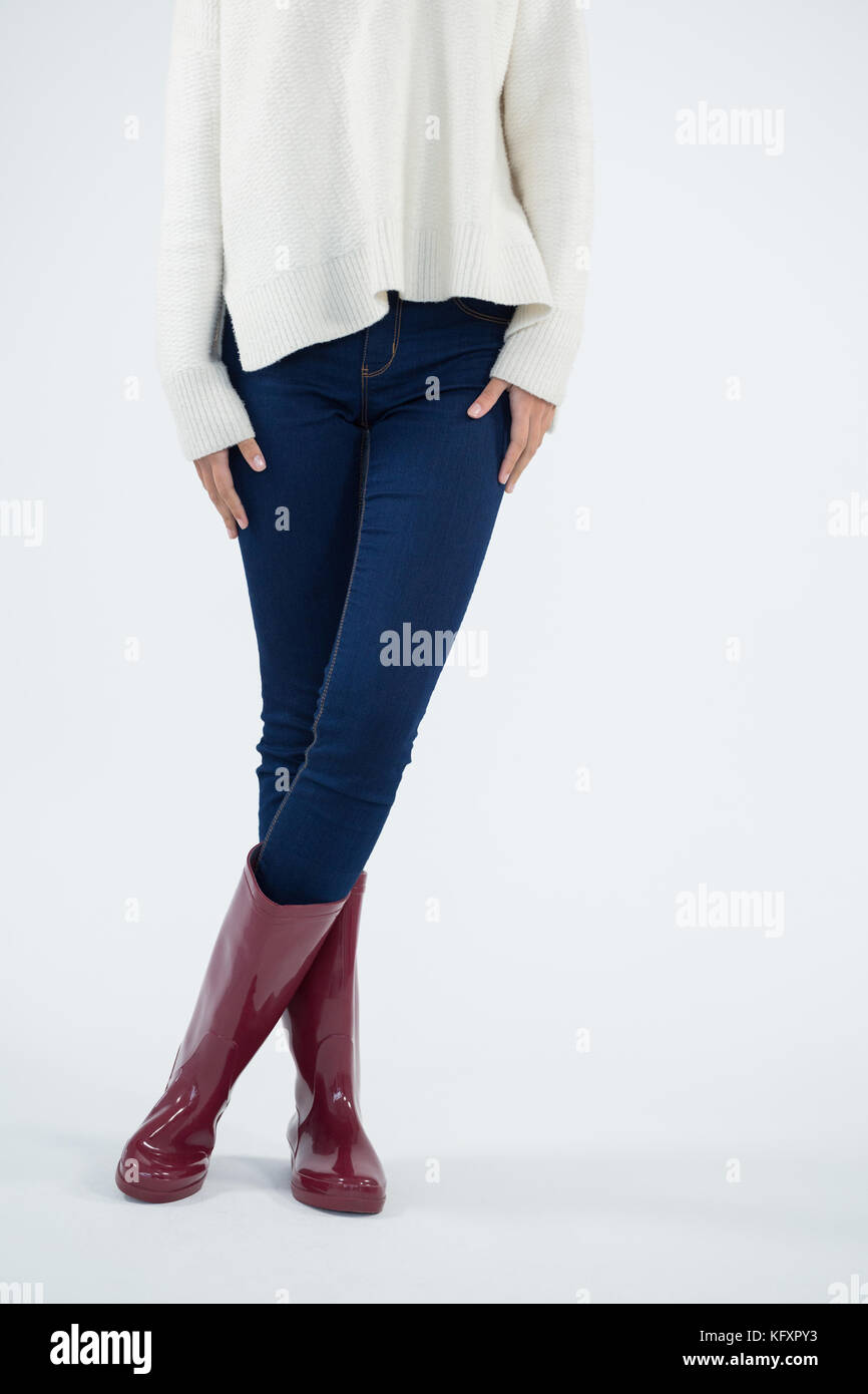 Woman in wellington boot standing with leg crossed against white ...