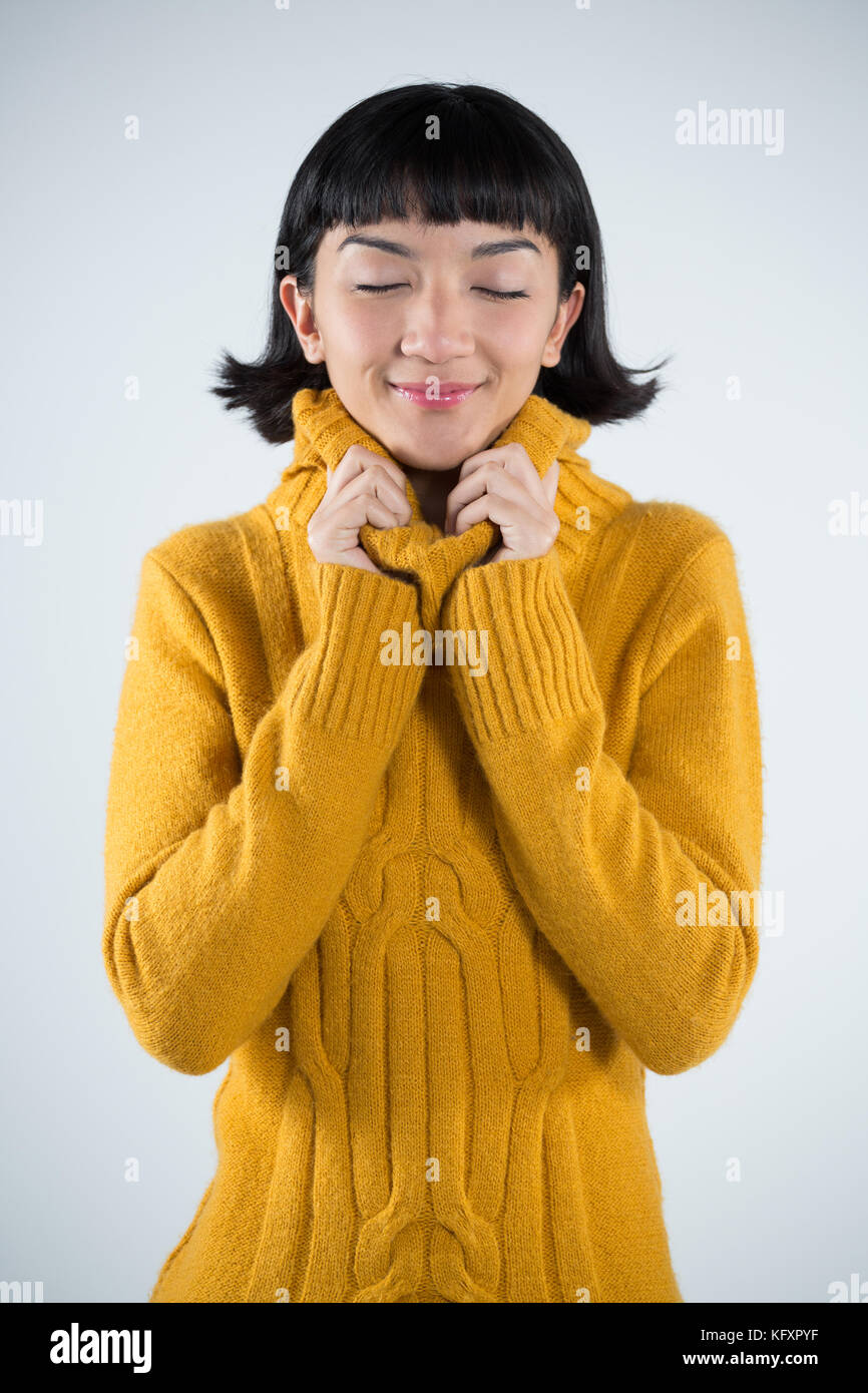 Blissful woman in winter clothing posing against white background Stock ...