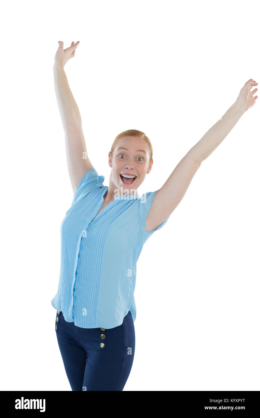 Young female executive standing with arms up against white background ...