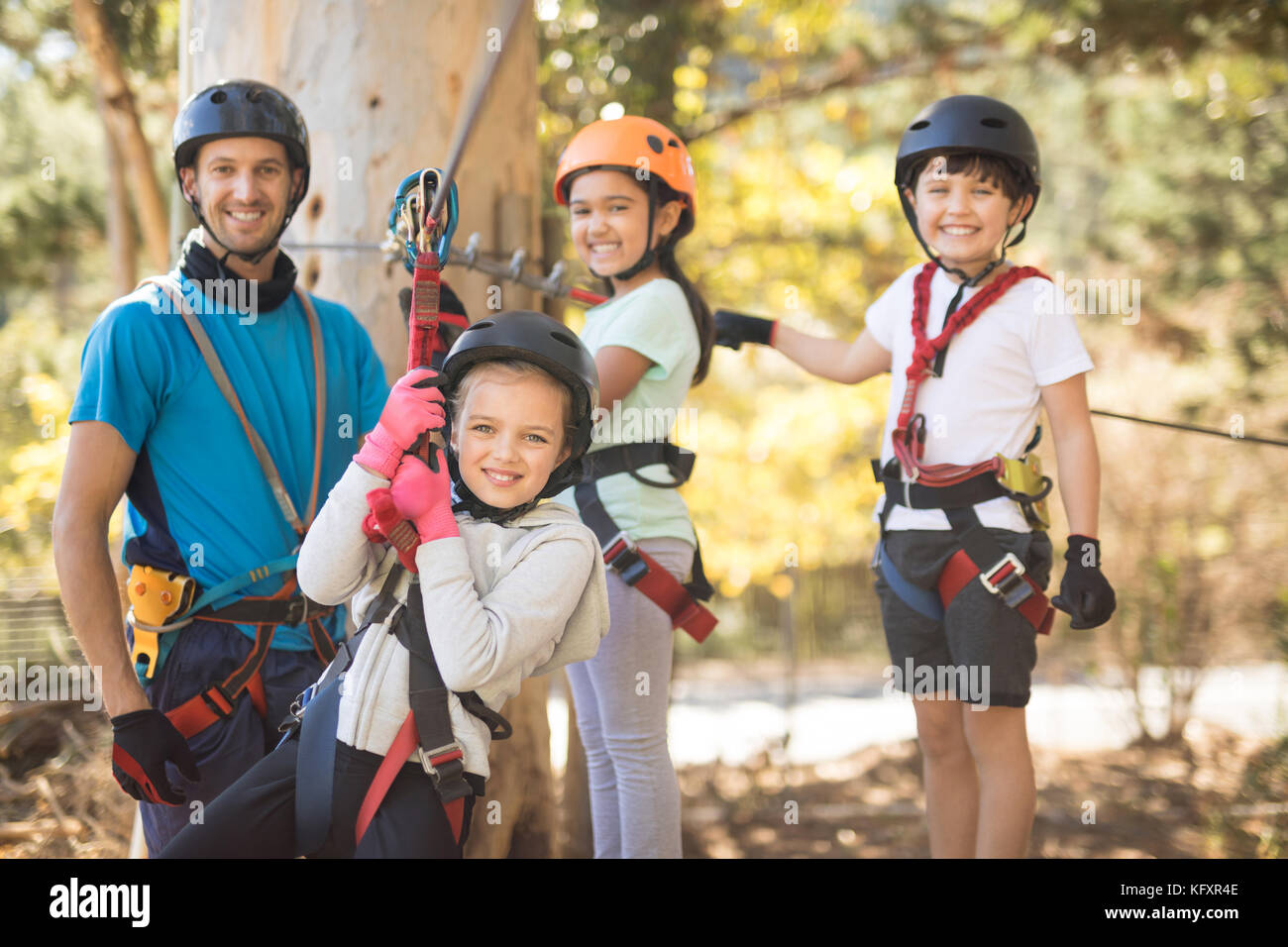 Happy kids enjoying zip line adventure on sunny day Stock Photo - Alamy