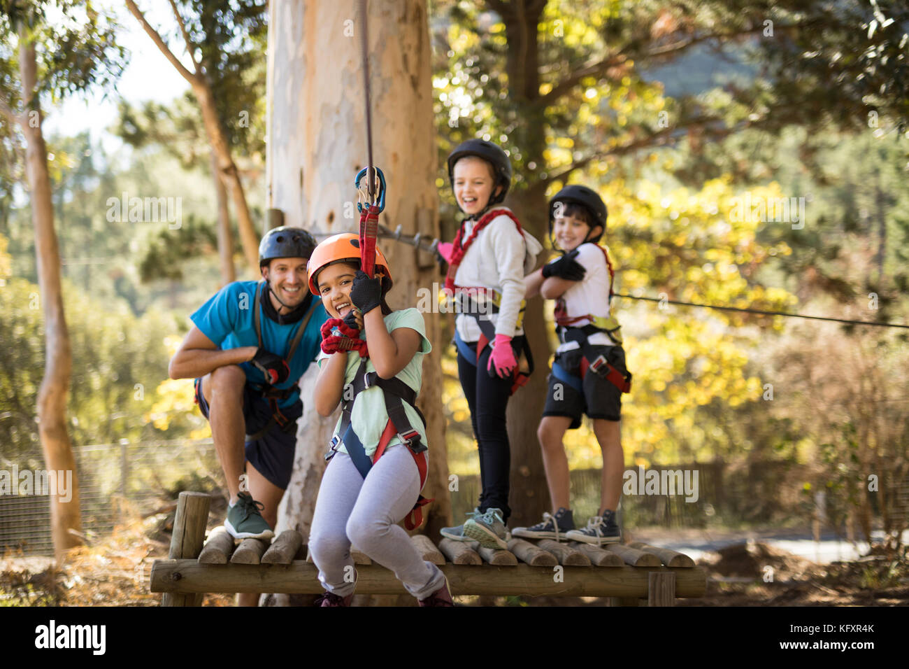 Happy kids enjoying zip line adventure on sunny day Stock Photo - Alamy