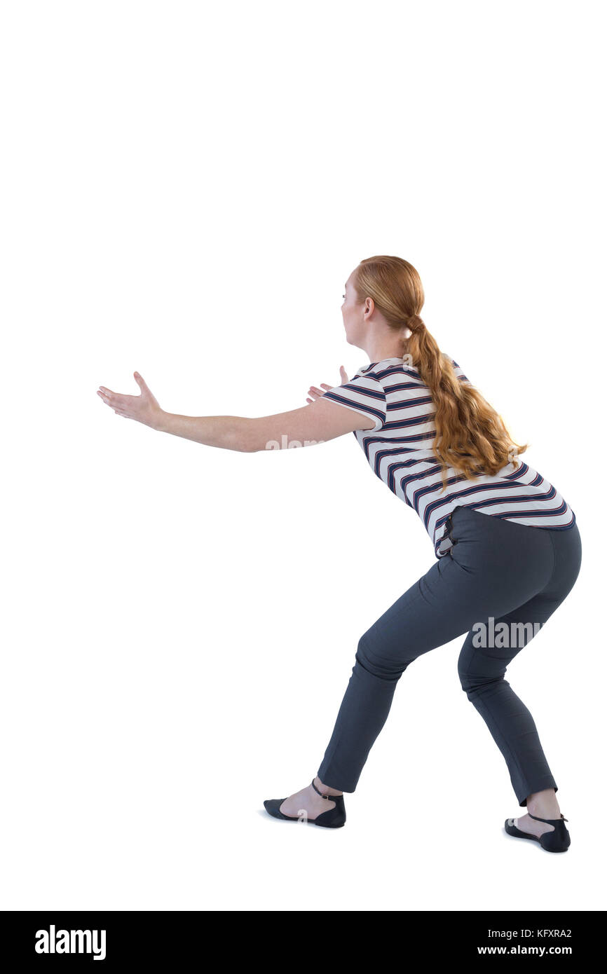 Woman pretending to hold an invisible object against white background ...