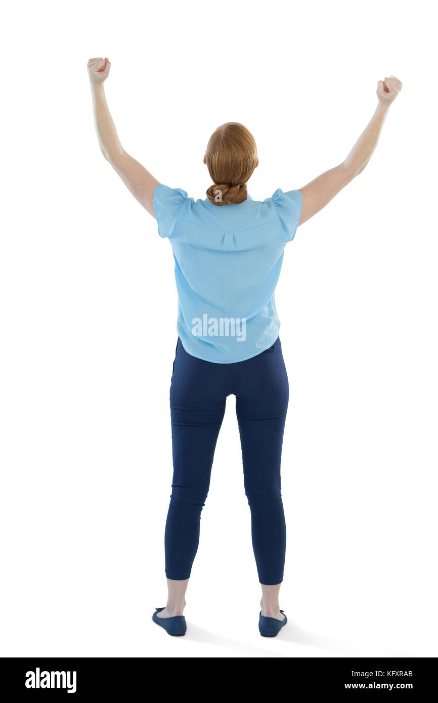 Rear view of female executive standing with arms up against white ...
