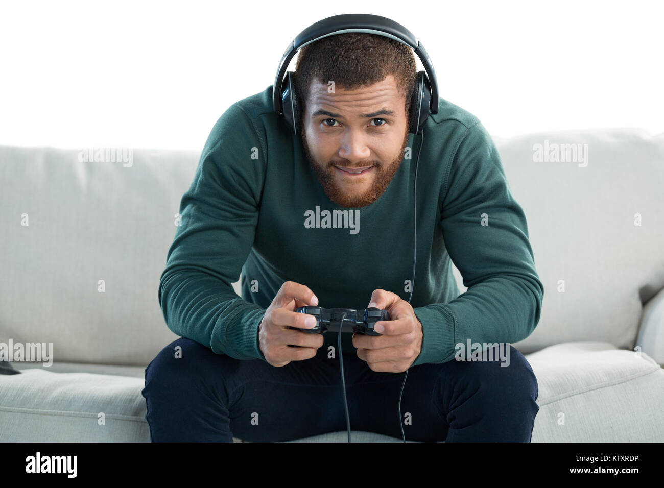 Smiling man playing video game against white background Stock Photo - Alamy