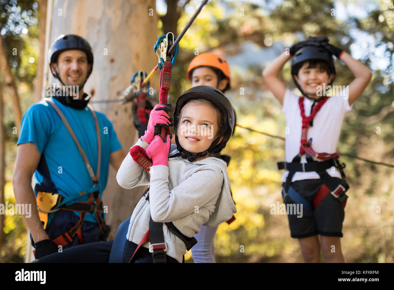 Smiling cute girl enjoying zip line adventure on sunny day Stock Photo ...