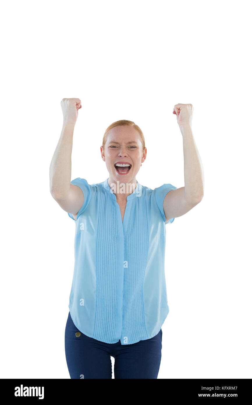 Young female executive standing with arms up against white background ...