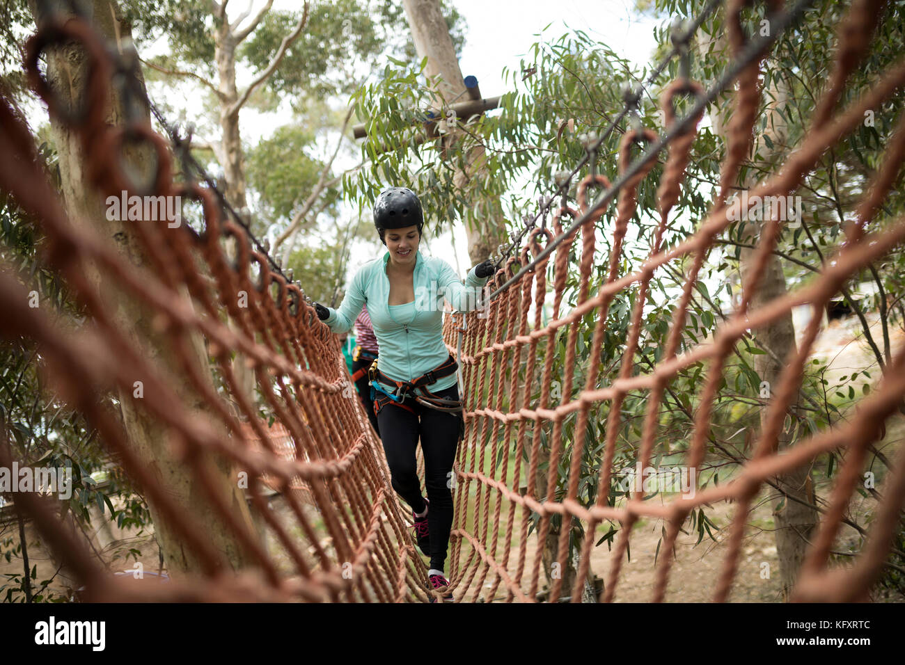 Beautiful woman walking on rope bridge Stock Photo - Alamy