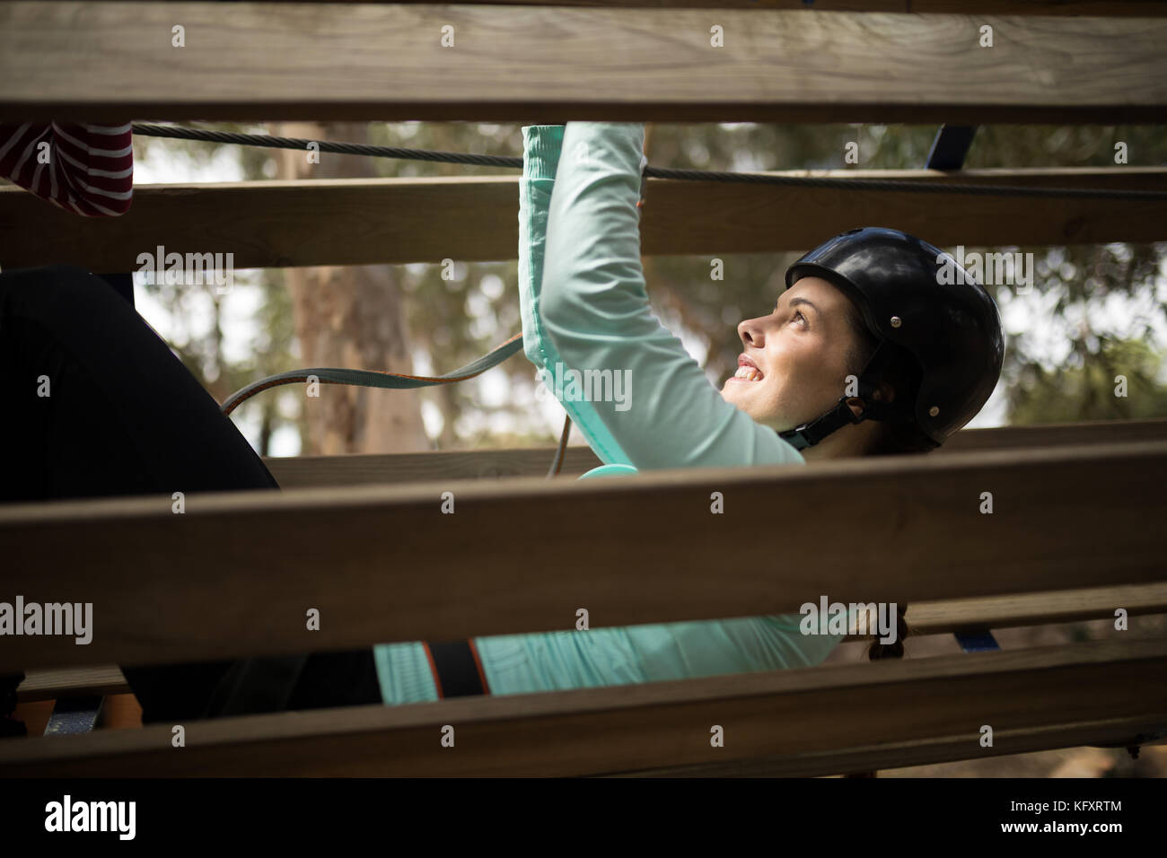 Smiling woman sliding on wooden slide in park Stock Photo - Alamy