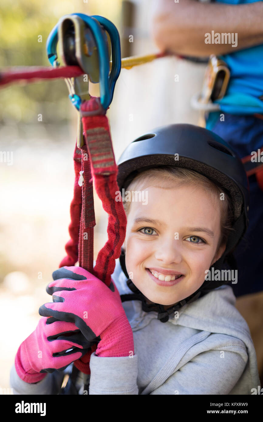 Smiling cute girl enjoying zip line adventure on sunny day Stock Photo ...