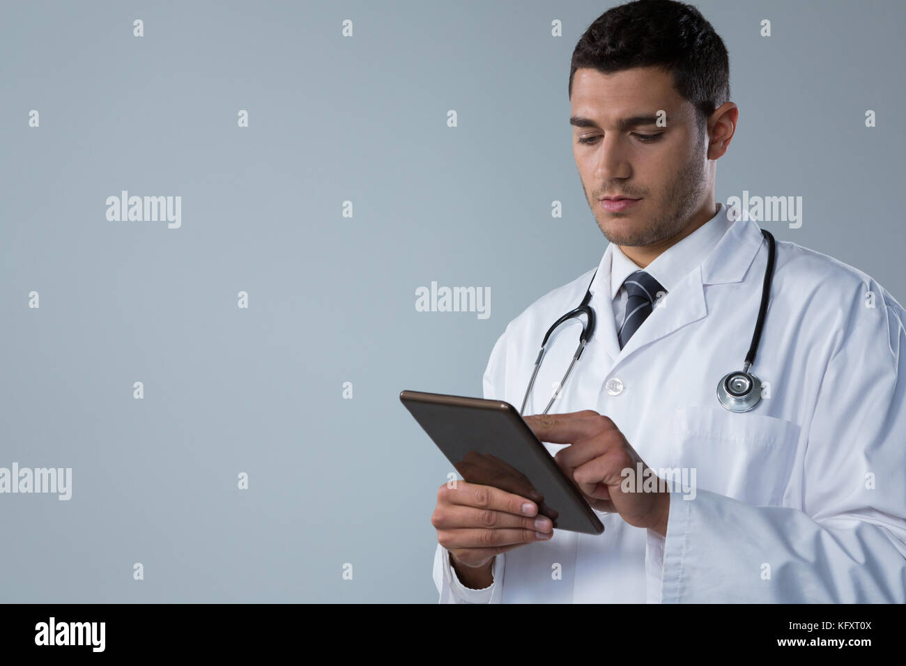 Doctor using a digital tablet against white background Stock Photo - Alamy