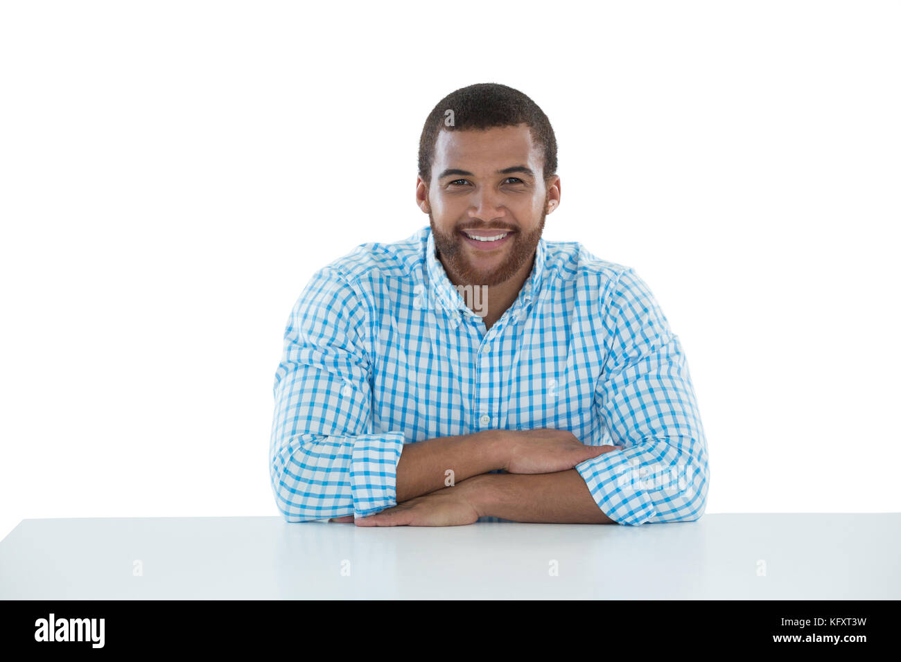 Male executive sitting at desk against white background Stock Photo - Alamy