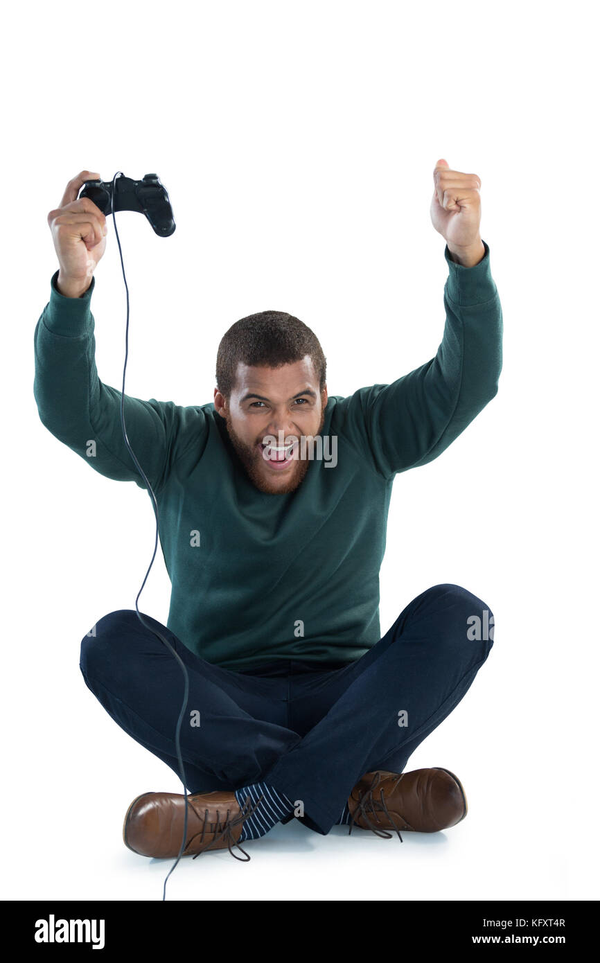 Excited man playing video games against white background Stock Photo ...