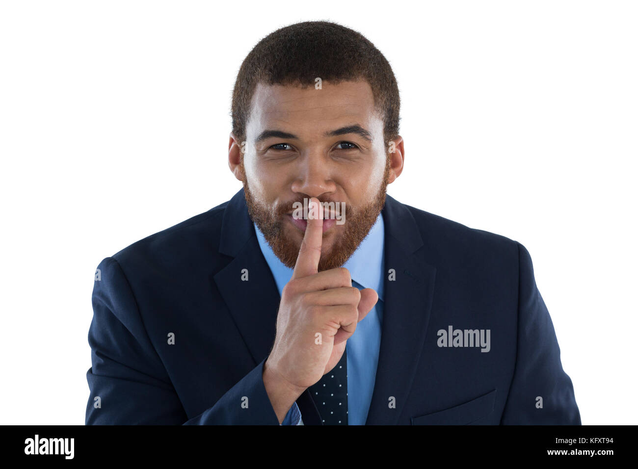 Businessman standing with finger on lips against white background Stock ...