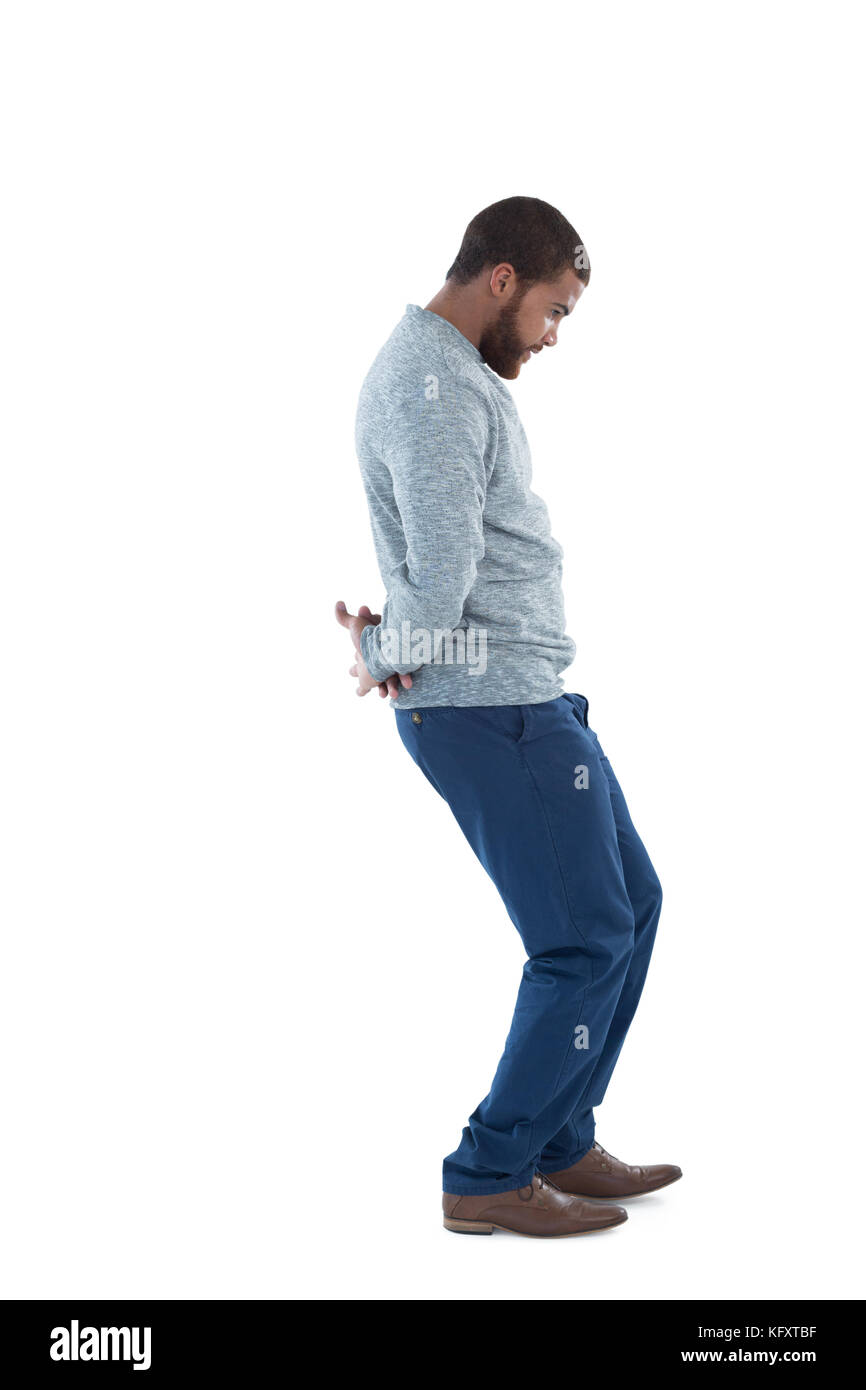 Young male executive pushing behind against white background Stock ...