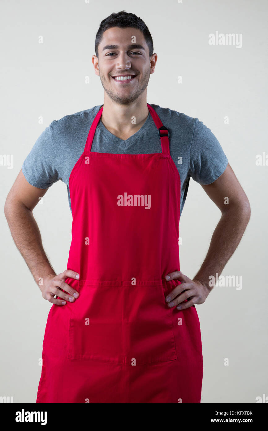 Portrait of smiling waiter standing with hands on hip Stock Photo - Alamy