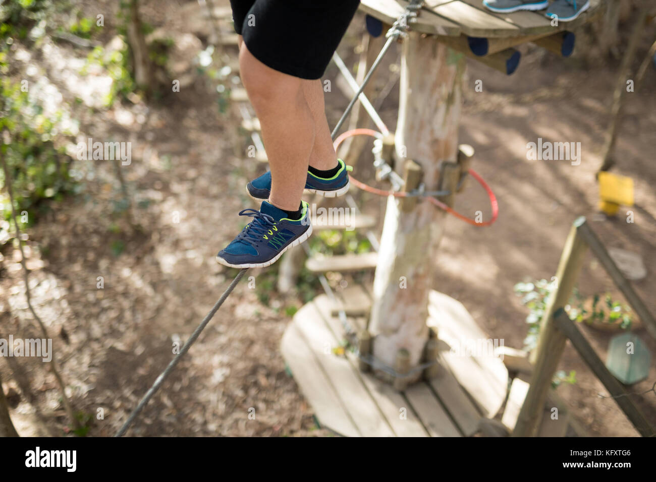 Low section of man walking on rope Stock Photo - Alamy
