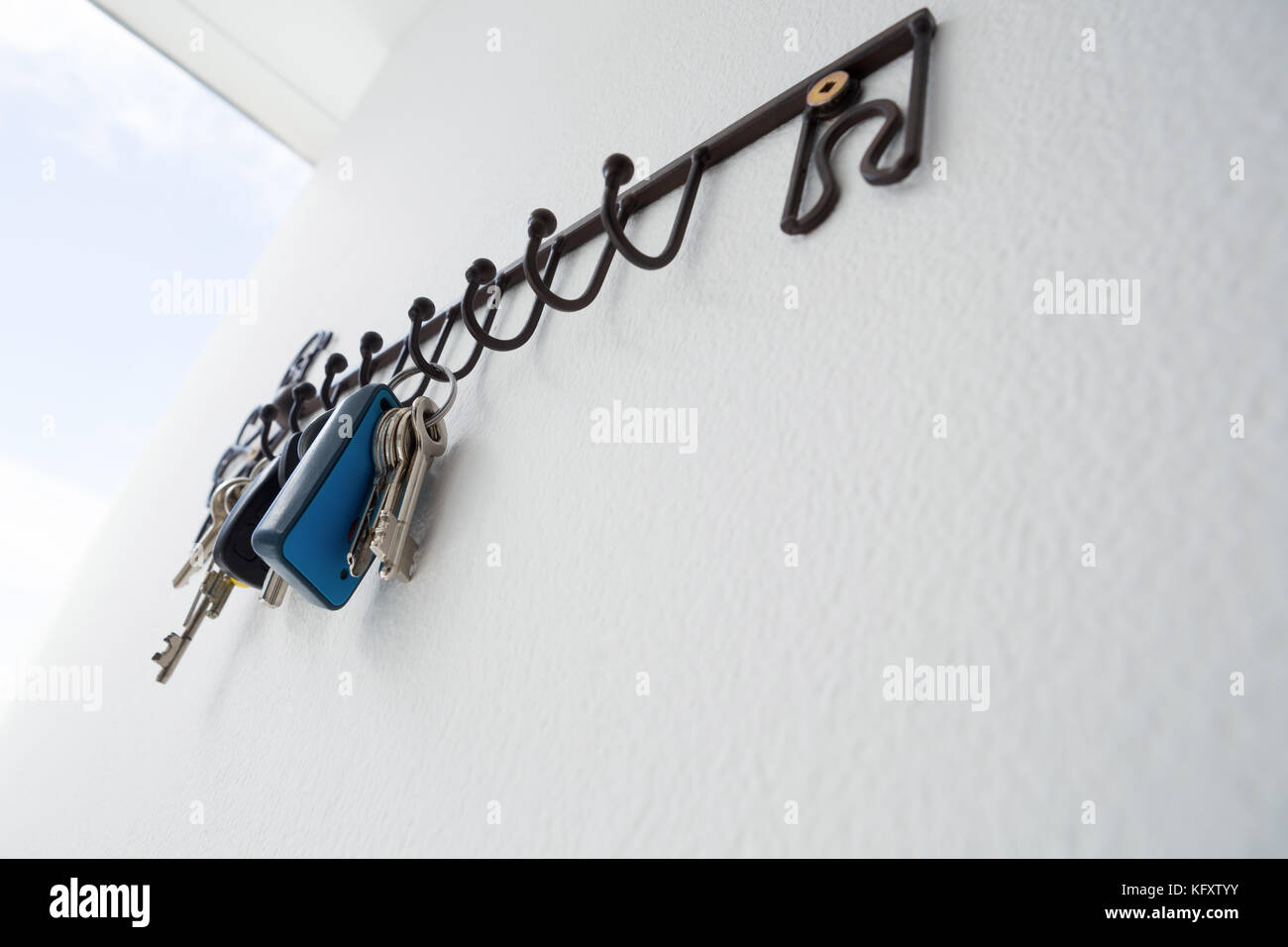 Low angle of various keys hanging on hook against wall Stock Photo - Alamy