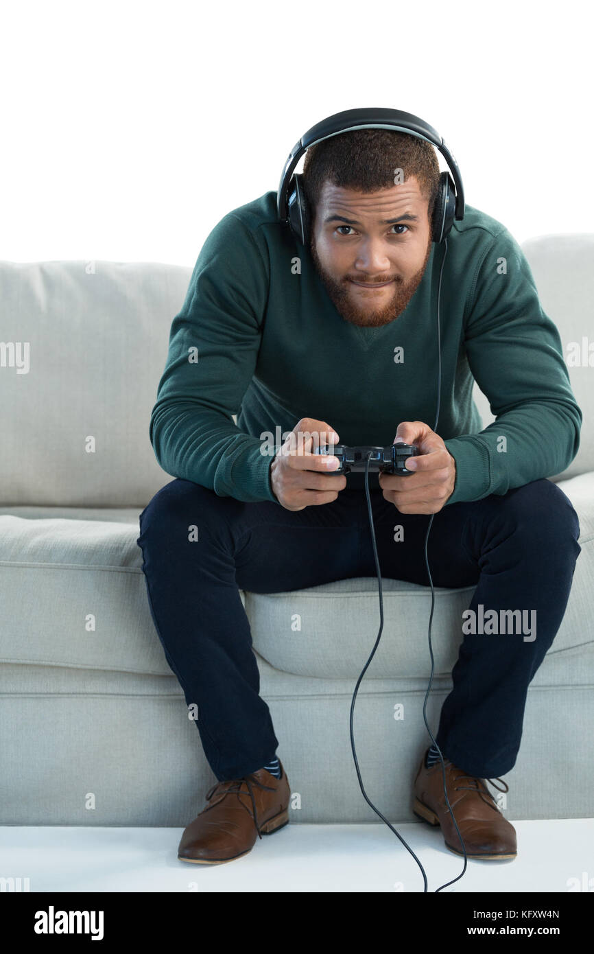 Smiling man playing video game against white background Stock Photo - Alamy