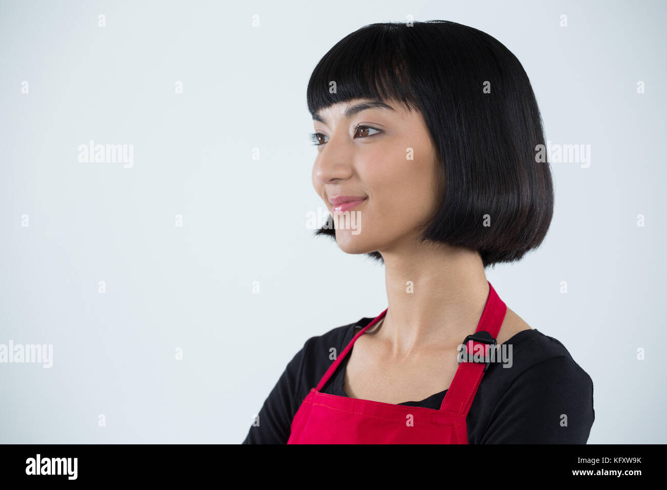 Smiling waitress standing against white background Stock Photo - Alamy
