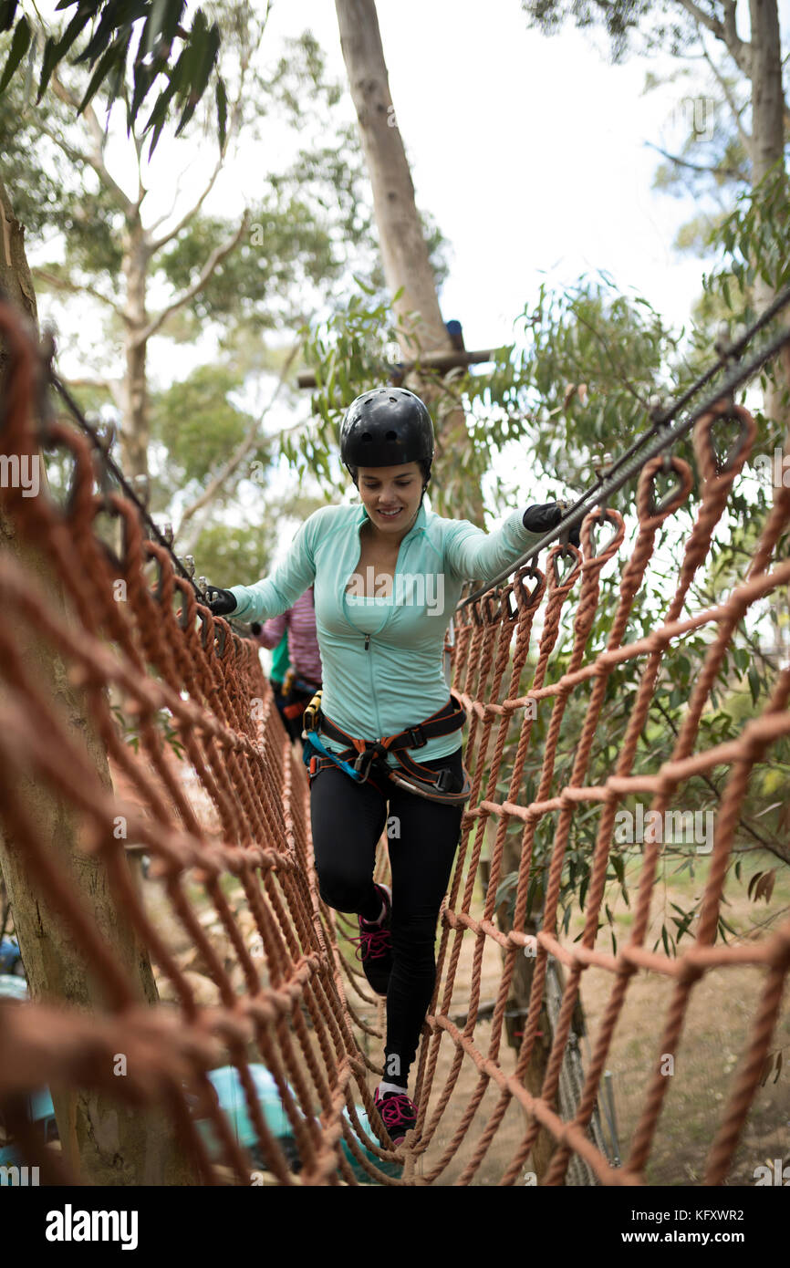 Beautiful woman walking on rope bridge Stock Photo - Alamy