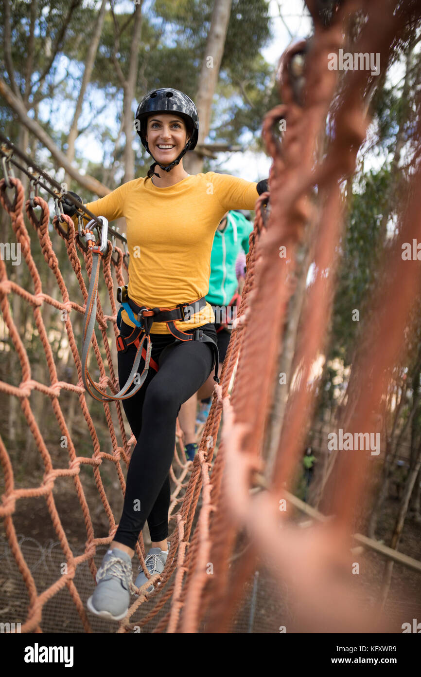 Happy woman walking on rope bridge Stock Photo - Alamy