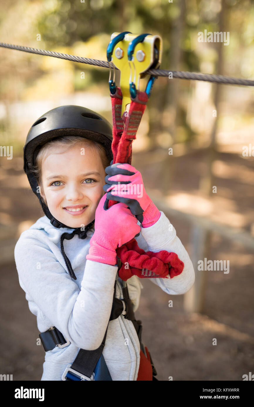 Smiling cute girl enjoying zip line adventure on sunny day Stock Photo ...