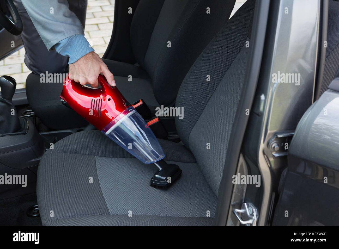 Male auto service staff cleaning car with portable vacuum Stock Photo ...