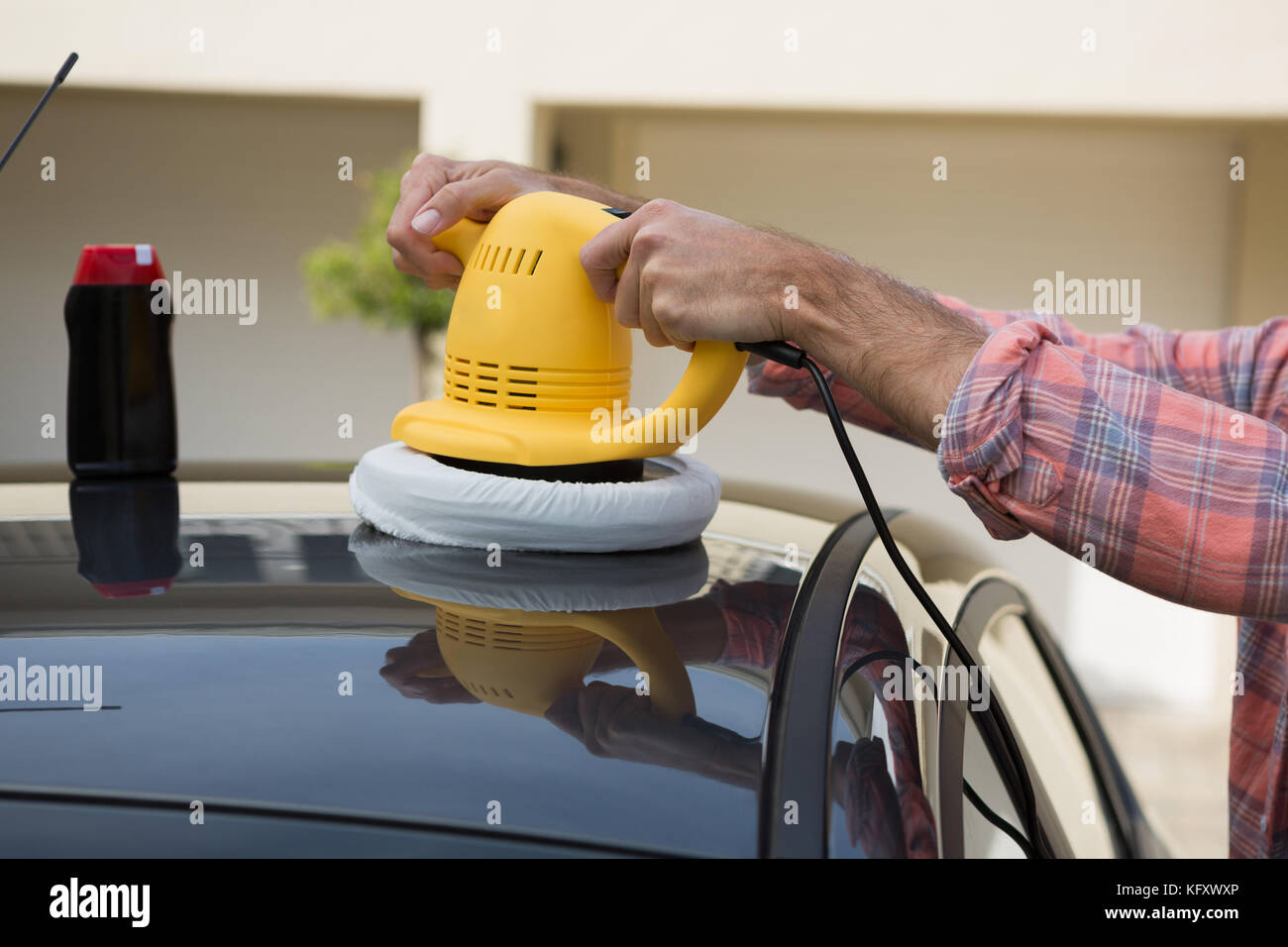 Male auto service staff cleaning a car with rotating wash brush Stock ...
