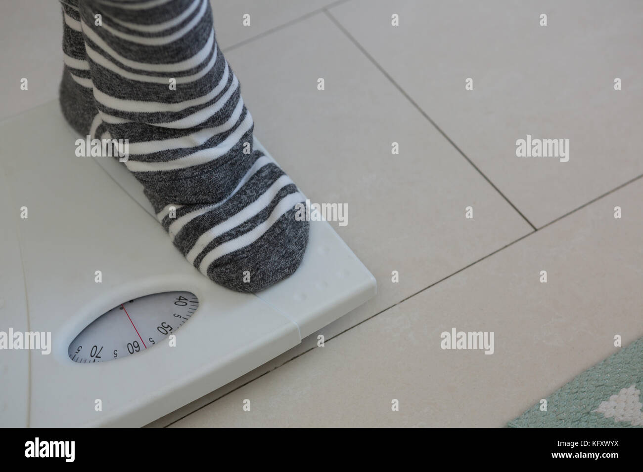 Woman checking her weight at home Stock Photo - Alamy