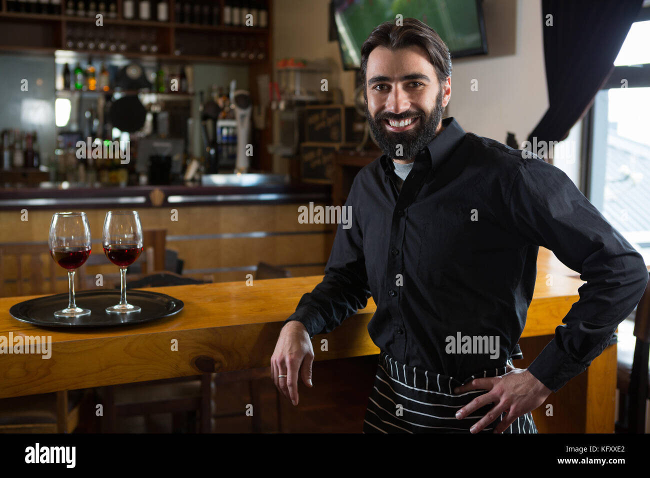Portrait of happy bar tender leaning at bar counter Stock Photo - Alamy