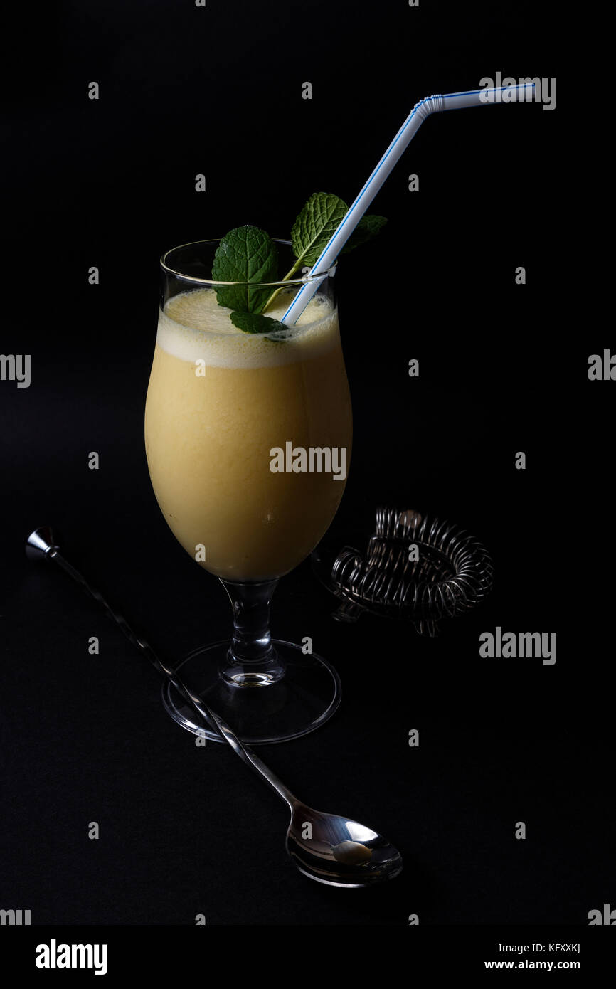 Cocktail of piña colada with mint next to cocktail accessories on a ...