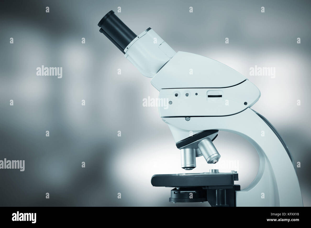 Microscope in laboratory against empty chairs in modern meeting room ...