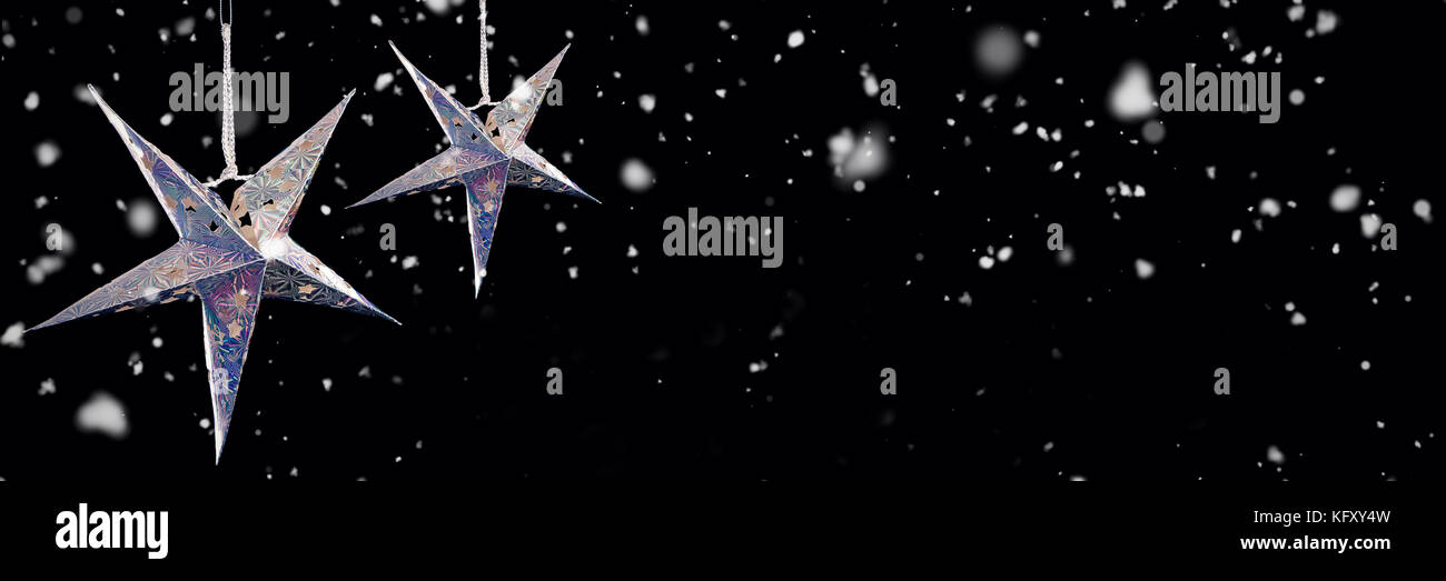 Snow falling against parol hanging against black background Stock Photo ...