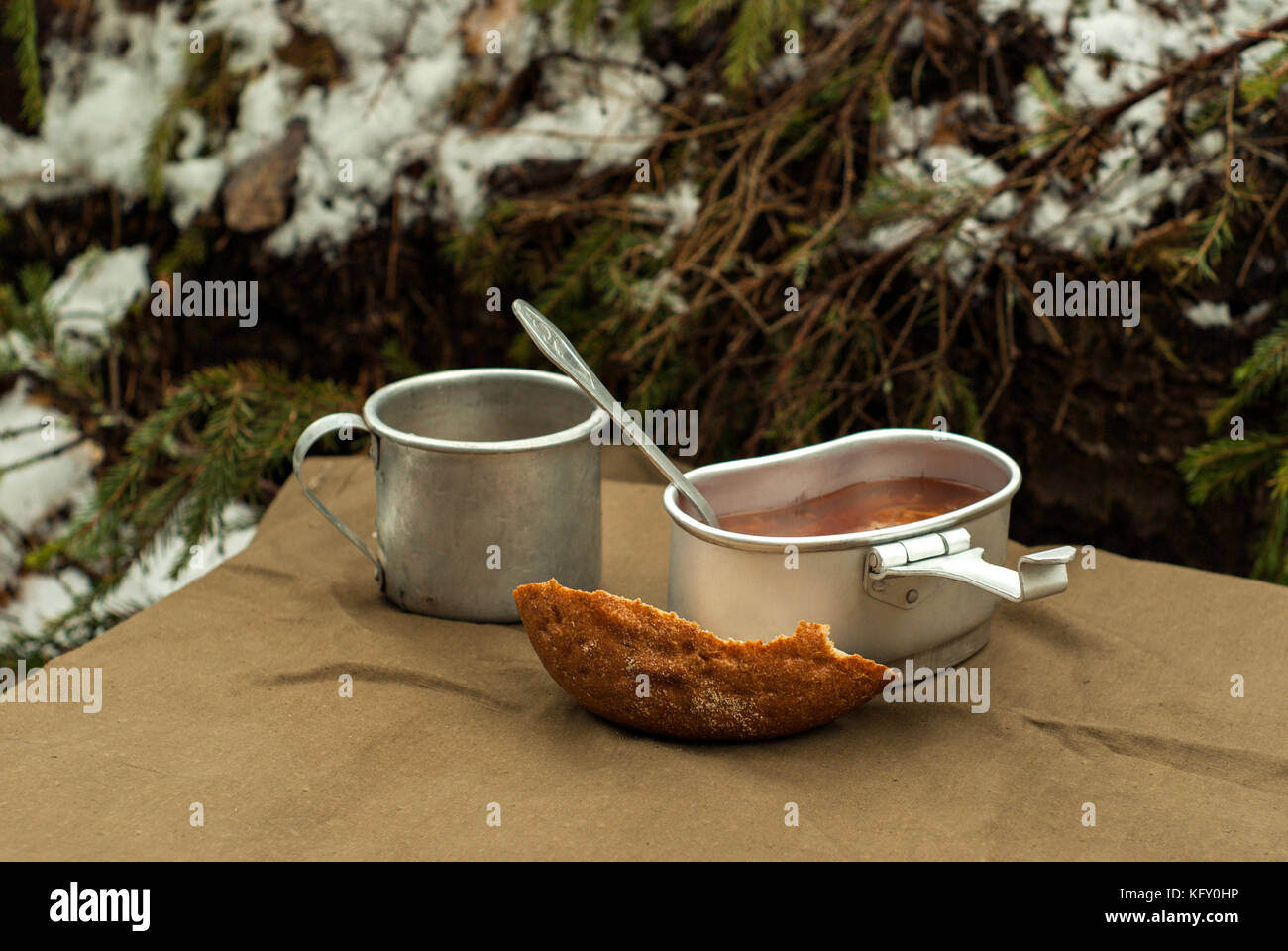 a scanty road meal: soup in a mess tin, a drink in a vintage army mug ...