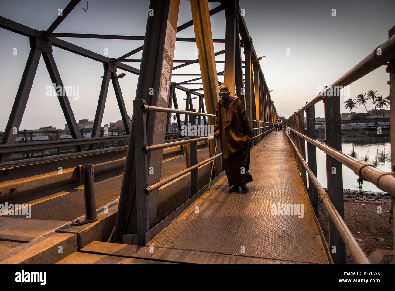 Old man crossing bridge in Saint-Louis Stock Photo - Alamy