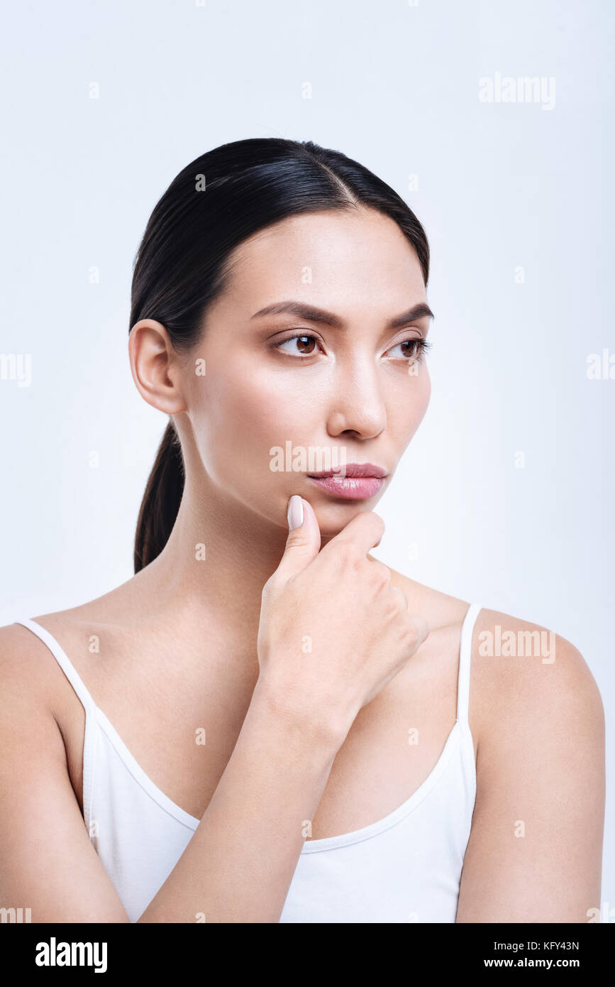 Beautiful young woman touching her chin while posing Stock Photo - Alamy