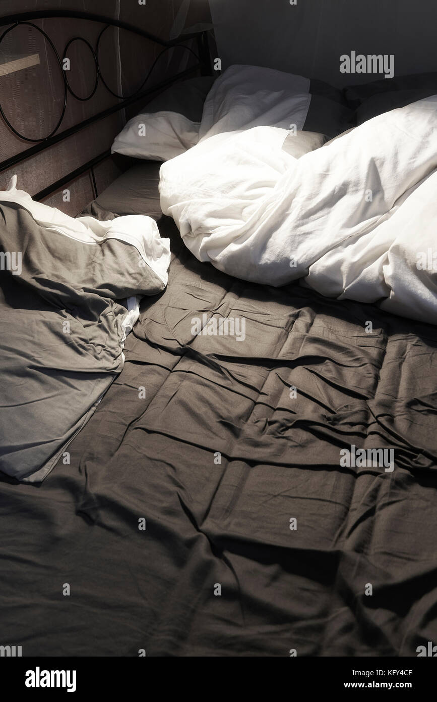 Disheveled sheets and pillows of an unmade bed,led light and Mosquito ...