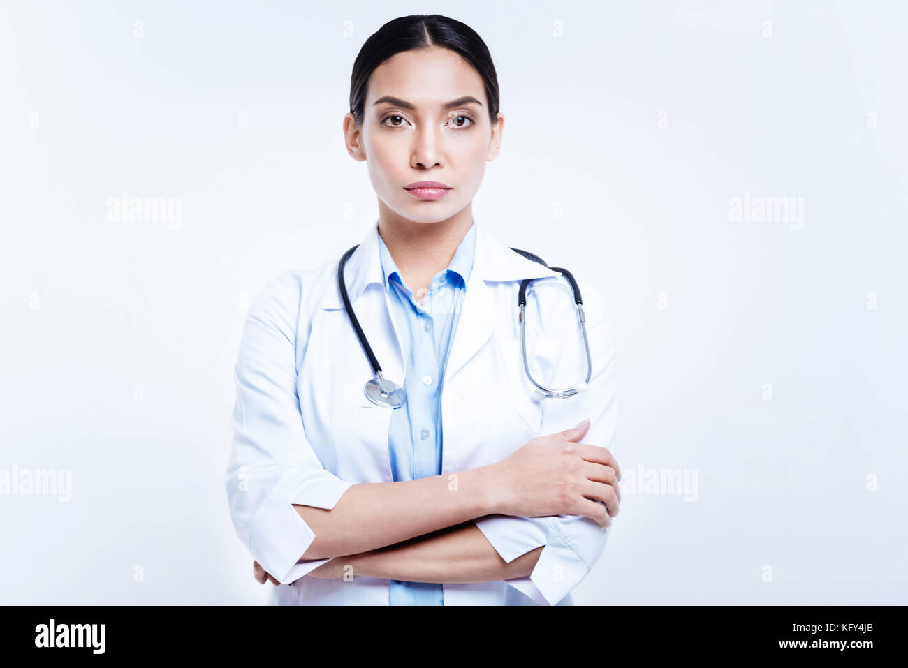 Pretty female doctor posing with her arms folded Stock Photo - Alamy