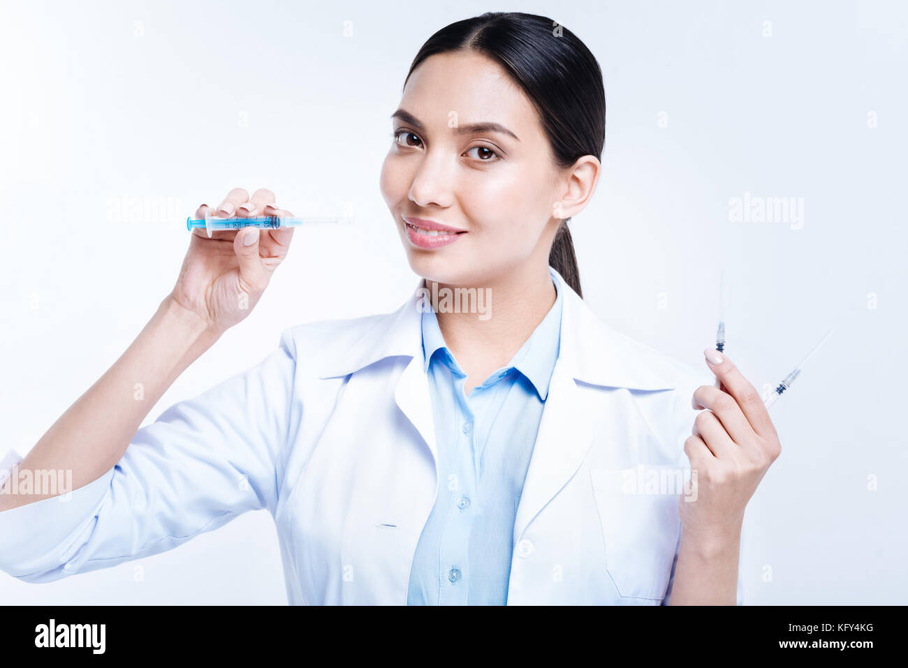 Cheerful female doctor holding three syringes Stock Photo - Alamy